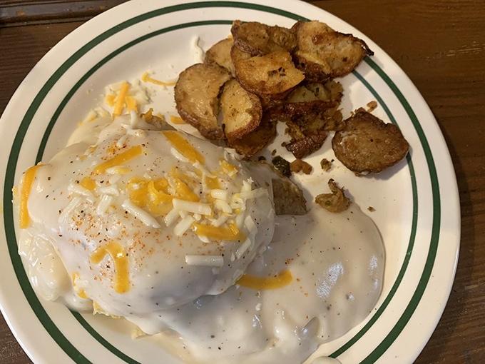 This plate is what breakfast dreams are made of – a golden biscuit swimming in creamy sausage gravy, with a side of crispy potatoes.