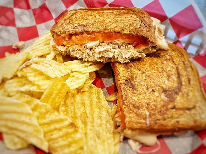 Golden-grilled bread reveals its molten treasure within—a tuna melt that puts ordinary versions to permanent shame.