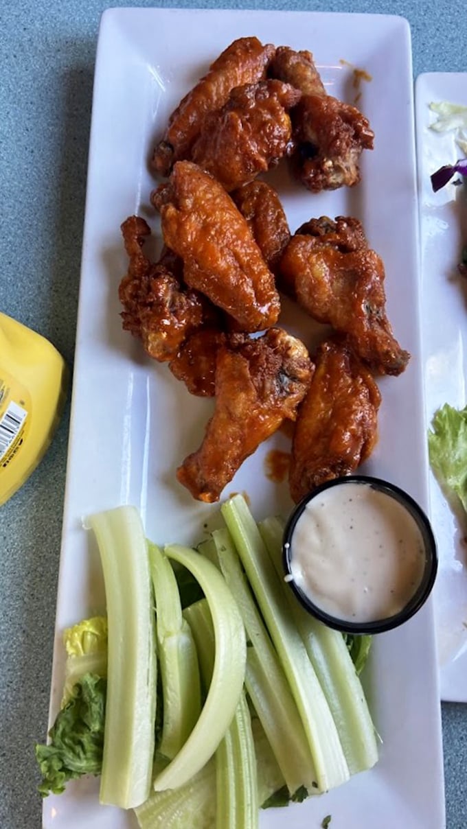 Buffalo sauce that clings to each wing like it's afraid of falling off—paired with celery sticks that know they're just along for the ride.