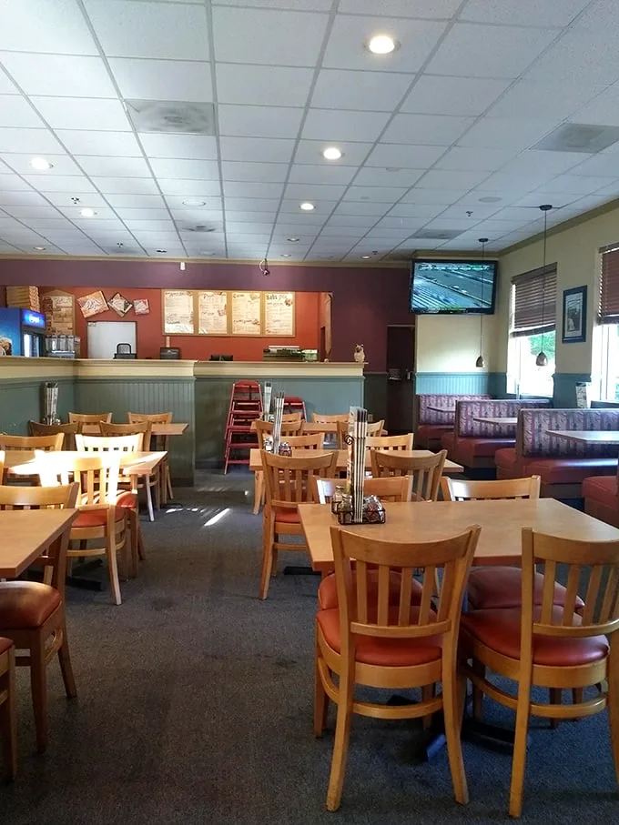 Those wooden chairs and orange booths aren't just seating—they're front-row tickets to the rectangular pizza show that's been running for decades.