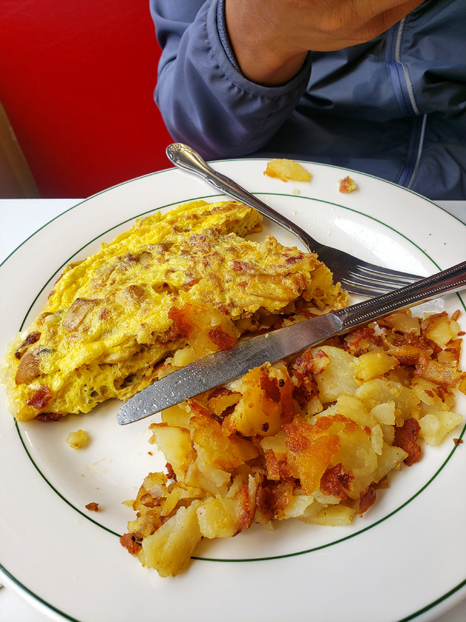 This isn't just an omelet—it's a golden envelope of happiness, delivering joy alongside those perfectly crisped home fries.