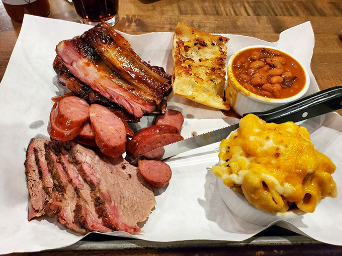 The holy trinity of barbecue on one tray. Brisket, ribs, and sausage playing the most delicious game of rock-paper-scissors ever.