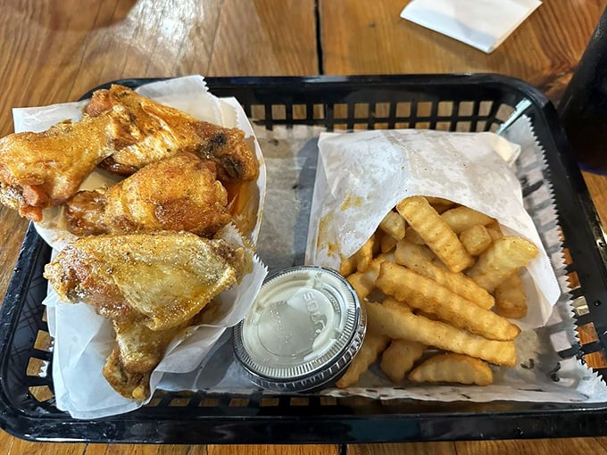 Golden-fried wings nestled beside crispy fries—a basket of happiness that makes you wonder why you'd ever eat anything else.