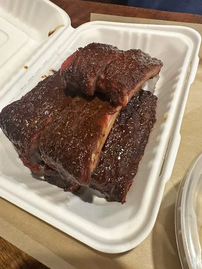A plate that dreams are made of! Tender ribs, sweet potato fries, and a side that looks suspiciously like BBQ nirvana.
