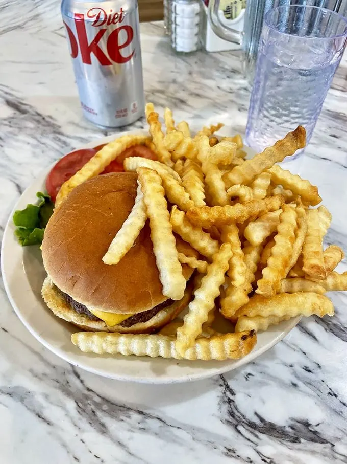 The classic American duo: burger and fries. This plate screams "comfort food" louder than your mom yelling "Dinner's ready!" on a summer evening.
