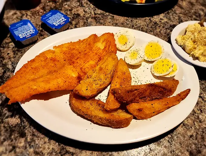 Golden-fried perfection alongside eggs and potatoes—the breakfast trinity that makes mornings worth facing. Even the plate looks happy.