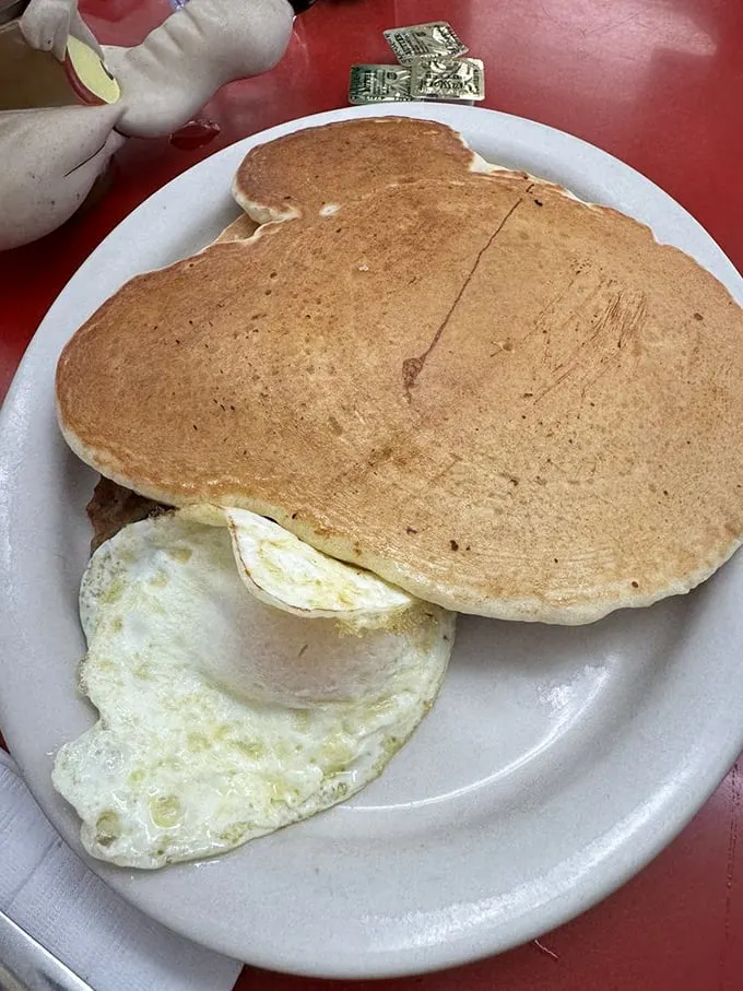 Pancakes so perfectly golden they deserve their own currency. That egg isn't just sunny-side up—it's beaming with breakfast joy.