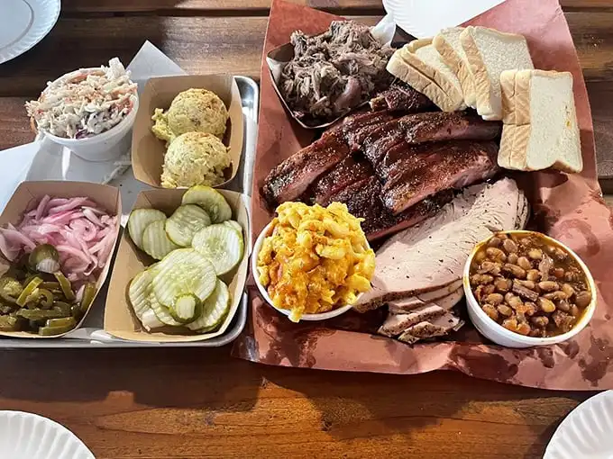 A barbecue spread that would make a vegetarian weep—meats in perfect formation, flanked by colorful sides like loyal soldiers.