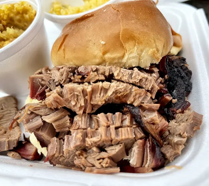Brisket bonanza! This sandwich is piled so high with tender, smoky goodness, it's like a meaty skyscraper for your mouth.