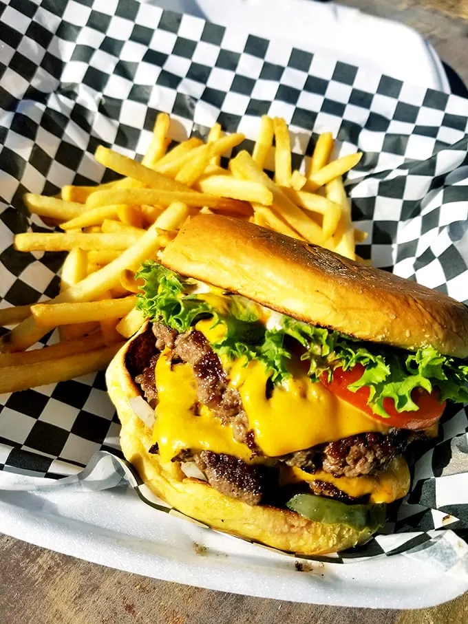 This isn't just a burger – it's architecture, engineering, and art all stacked between two buns with fries standing guard on the side.