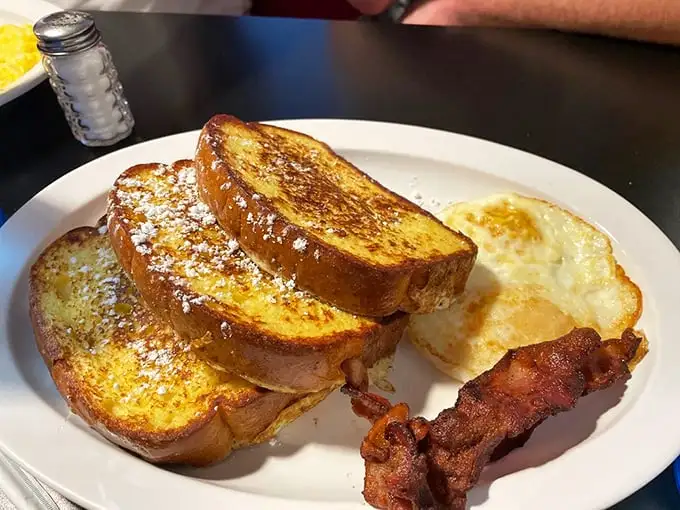 French toast that makes regular bread feel inadequate. Paired with bacon that's achieved that magical balance between crisp and chewy – breakfast alchemy at its finest.