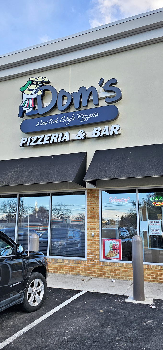 The cartoon chef on Dom's sign isn't just cute—he's making a solemn vow about New York pizza authenticity that Delaware residents desperately needed.