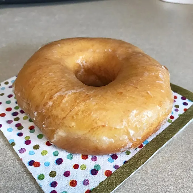 Simple perfection on a polka-dot napkin. This glazed doughnut is the little black dress of the pastry world – timeless, elegant, and always in style.