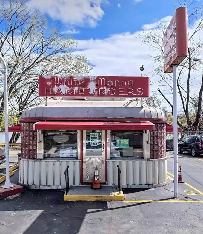 Neon dreams and burger schemes! White Manna's iconic sign beckons like a lighthouse for the hungry, guiding lost souls to slider salvation.