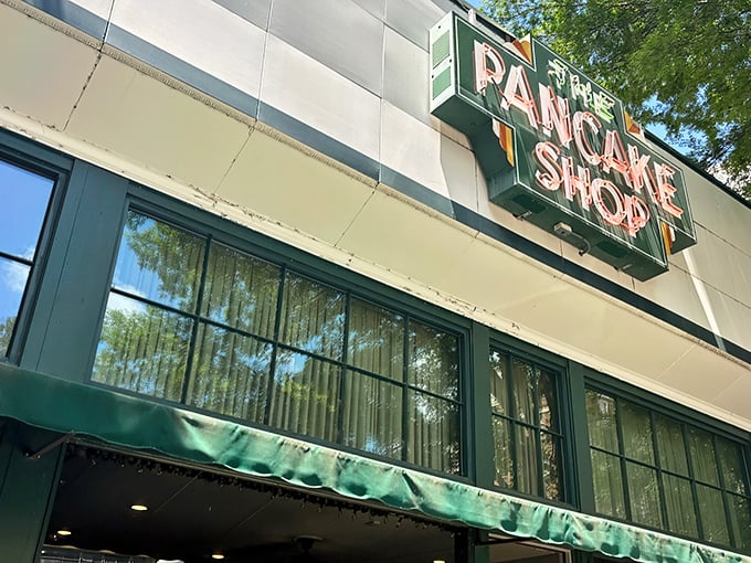 The iconic green awning and vintage sign of The Pancake Shop stands as a breakfast beacon on Hot Springs' Central Avenue, promising morning magic within.