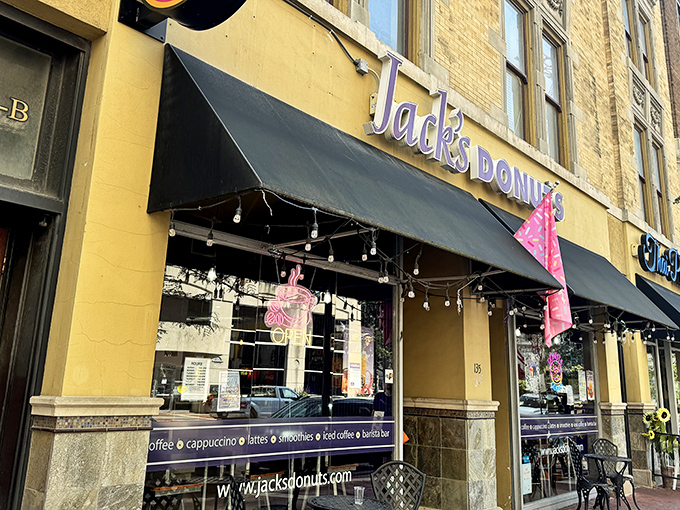 Jack's Donuts announces its presence with charming simplicity—a yellow brick building, black awning, and the promise of sweet satisfaction waiting inside.