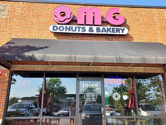 The pink donut sign beckons like a sugary lighthouse, promising sweet salvation for carb enthusiasts in Concord's unassuming strip mall. 
