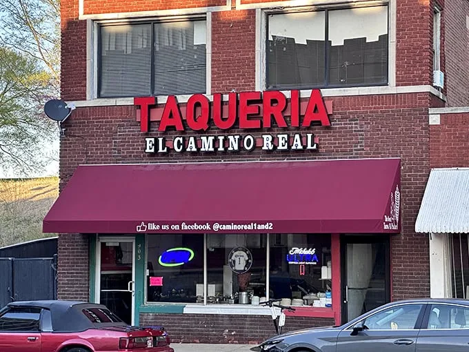The glowing red "TAQUERIA" sign against brick isn't just signage—it's a beacon of hope for hungry souls seeking authentic Mexican flavors in Kansas City.