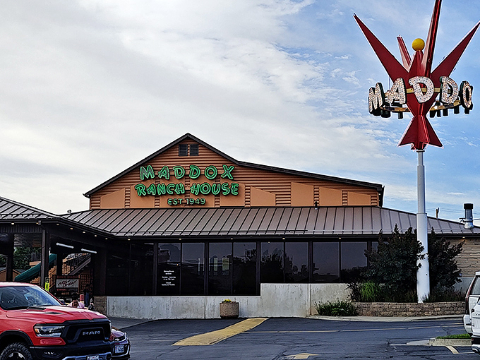 The glowing green sign of Maddox Ranch House beckons like a meaty lighthouse against the Utah mountains—a beacon of beef since 1949.