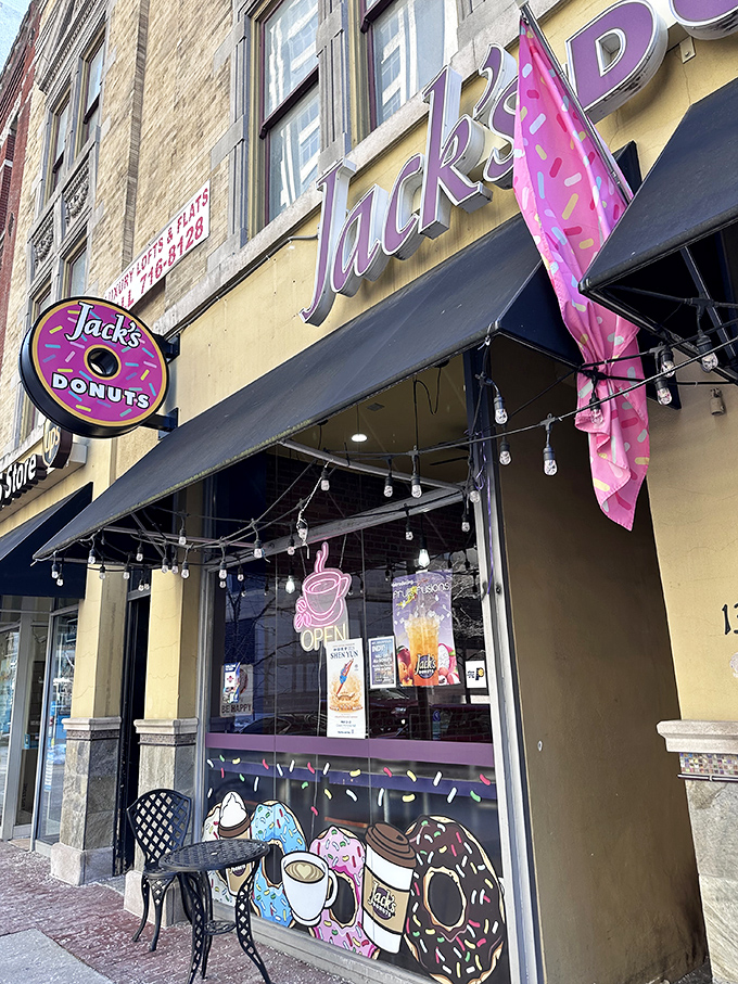 Jack's Donuts announces its presence with charming simplicity—a yellow brick building, black awning, and the promise of sweet satisfaction waiting inside.