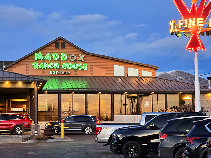 The glowing green sign of Maddox Ranch House beckons like a meaty lighthouse against the Utah mountains—a beacon of beef since 1949.
