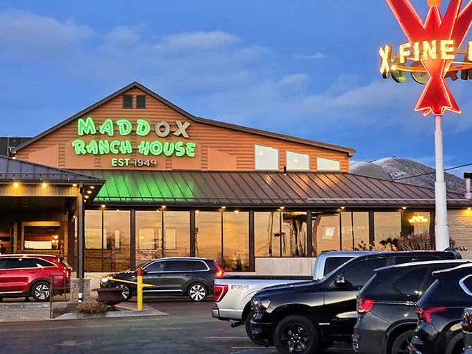 The glowing green sign of Maddox Ranch House beckons like a meaty lighthouse against the Utah mountains—a beacon of beef since 1949.