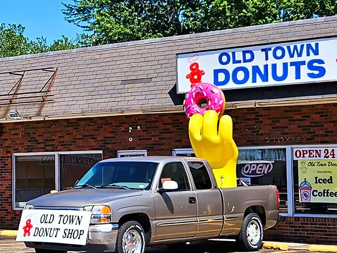 The legendary yellow hand with pink donut - Old Town Donuts' iconic mascot welcoming sugar-seekers 24/7. It's like the Statue of Liberty for the sweet-toothed.