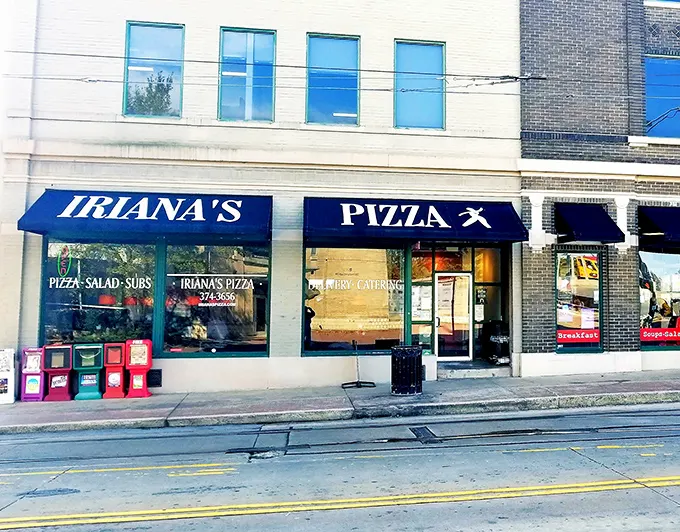 The unassuming storefront of Iriana's Pizza stands like a beacon of hope for hungry downtown Little Rock wanderers. Simple green frames, bold red sign—pizza paradise awaits.