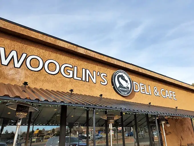 The stucco facade of Wooglin's Deli & Cafe welcomes hungry travelers with its distinctive dragon logo—a neighborhood landmark that promises comfort in sandwich form.