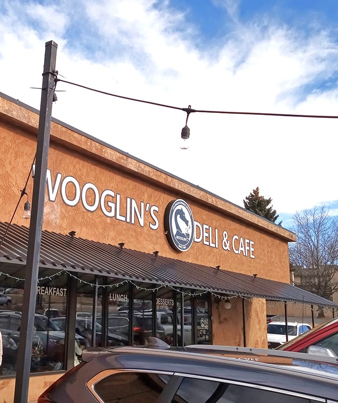 The stucco facade of Wooglin's Deli & Cafe welcomes hungry travelers with its distinctive dragon logo—a neighborhood landmark that promises comfort in sandwich form.