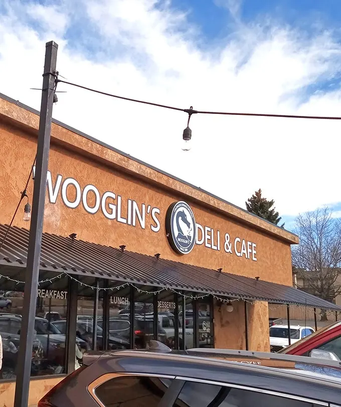 The stucco facade of Wooglin's Deli & Cafe welcomes hungry travelers with its distinctive dragon logo—a neighborhood landmark that promises comfort in sandwich form.