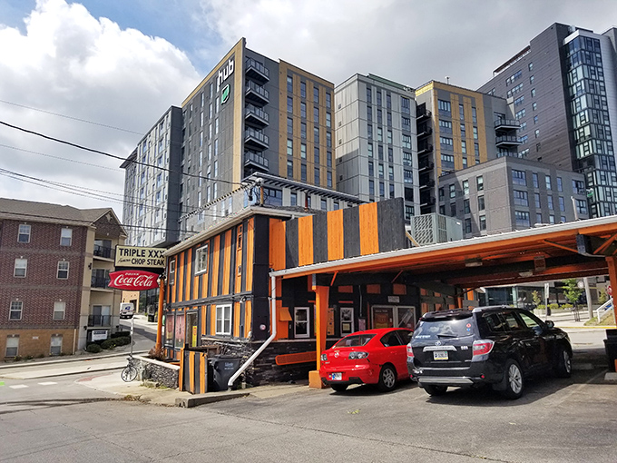 The iconic orange and black striped exterior stands defiant against modern architecture, like a time traveler who refuses to update their wardrobe. Pure Americana.