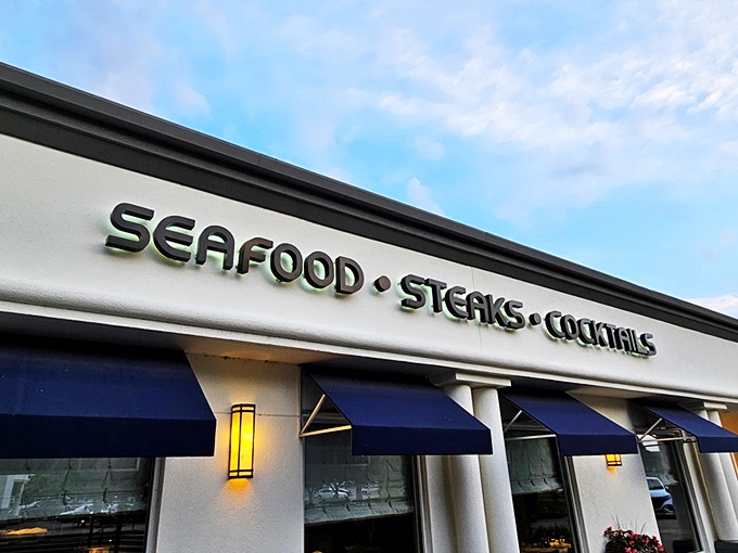 Newport Grill's exterior welcomes you with cheerful blue umbrellas and a sunny patio—like the Mediterranean coast decided to vacation in Kansas.