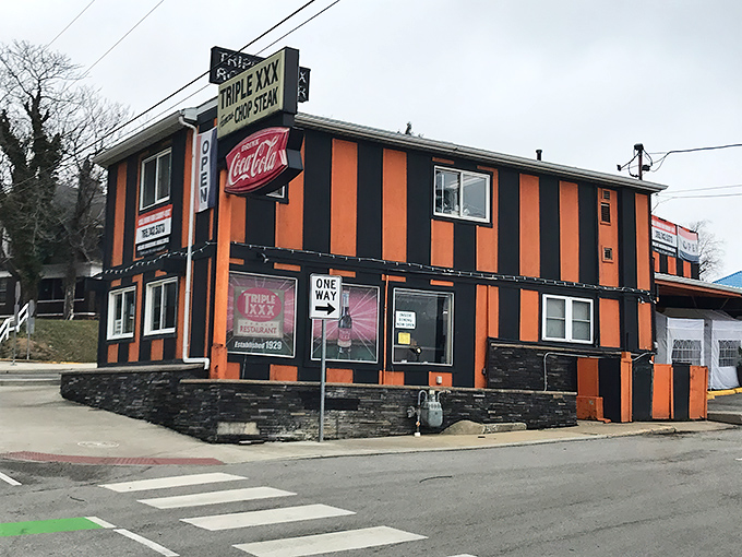 The iconic orange and black striped exterior stands defiant against modern architecture, like a time traveler who refuses to update their wardrobe. Pure Americana.
