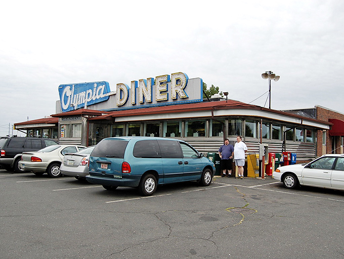 That neon sign isn't just advertising—it's a time machine. The Olympia's iconic blue and pink glow has been guiding hungry travelers home since Eisenhower was president.