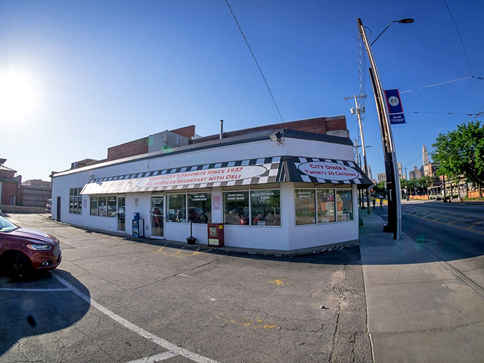 The classic white brick exterior with black and white striped awning stands like a time capsule on this Kansas City corner, beckoning hungry patrons with its humble charm.