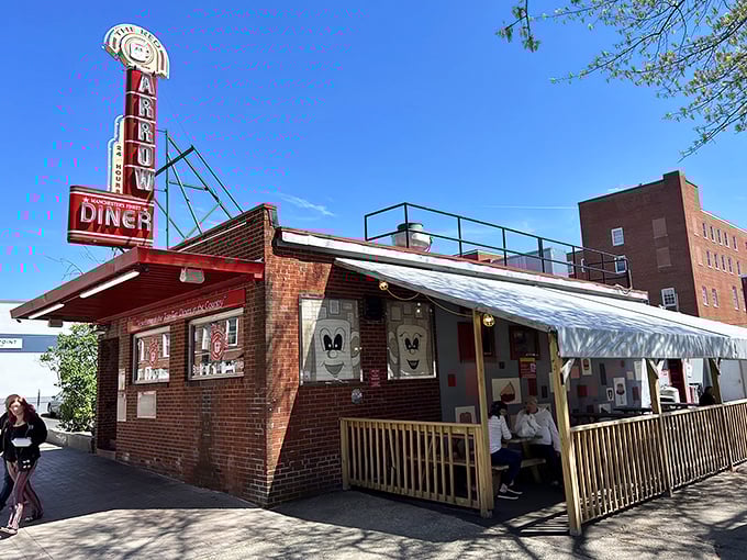 The iconic Red Arrow Diner storefront beckons hungry travelers with its vintage neon sign and promise of 24-hour comfort food. Manchester's brick-and-mortar time machine awaits.