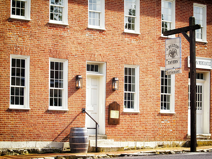The historic red brick exterior of J. Huston Tavern stands proudly in Arrow Rock, a time capsule of frontier hospitality since 1834.