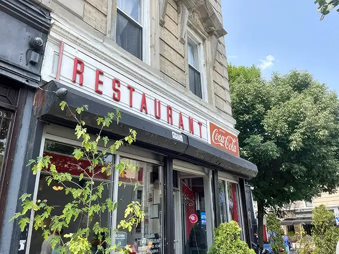 That iconic Coca-Cola sign and vintage storefront—Tom's Restaurant stands like a time capsule of old Brooklyn, promising breakfast bliss behind those doors.