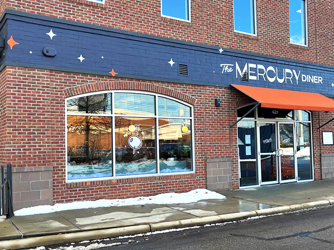 The Mercury Diner's navy blue facade with bright orange awning isn't just inviting—it's practically a bat signal for hungry Ohioans seeking comfort food nirvana.