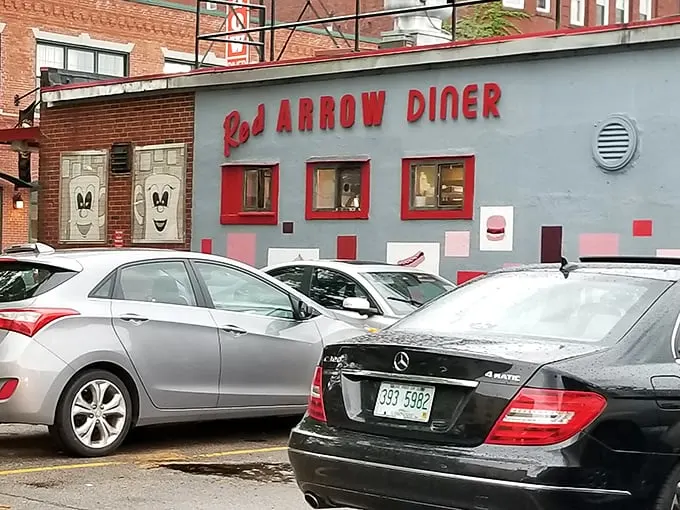The iconic Red Arrow Diner storefront beckons hungry travelers with its vintage neon sign and promise of 24-hour comfort food. Manchester's brick-and-mortar time machine awaits.