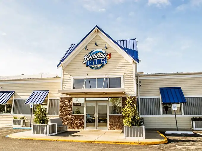 Bethany Blues' inviting exterior promises barbecue salvation with its distinctive blue roof and welcoming stone entrance—a coastal Delaware landmark that beckons hungry travelers.