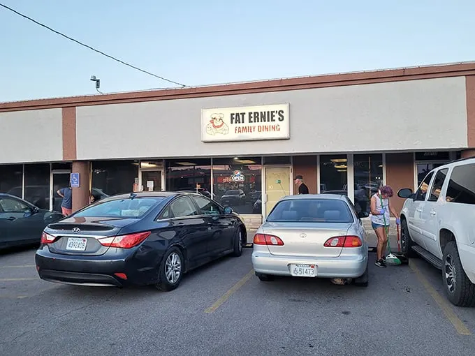 The unassuming exterior of Fat Ernie's Family Dining – where culinary treasures hide behind beige walls and a cartoon chef who seems to know something you don't.