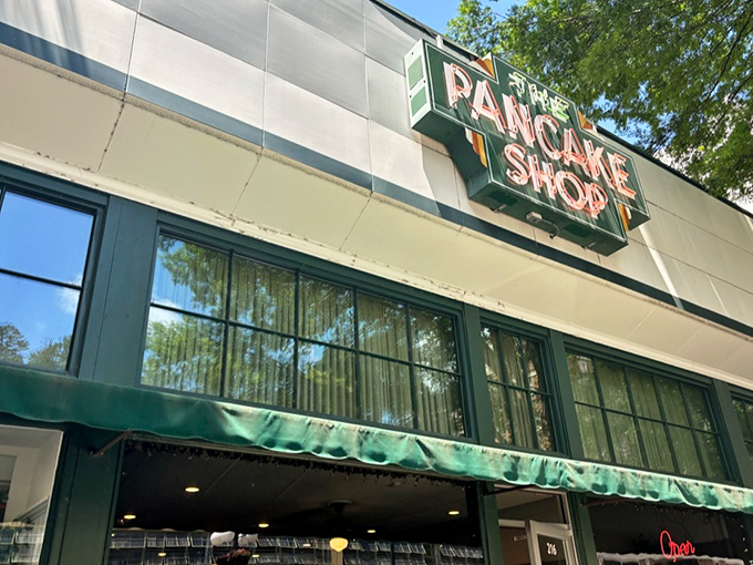 The iconic green sign beckons like a breakfast lighthouse on Hot Springs' Central Avenue, promising pancake perfection to early risers and brunch enthusiasts alike.