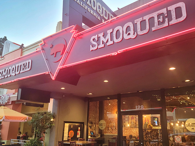 The pink pig silhouette perched atop Smoqued's sign isn't just cute – it's a beacon of hope for BBQ lovers wandering the California desert of mediocre meat.