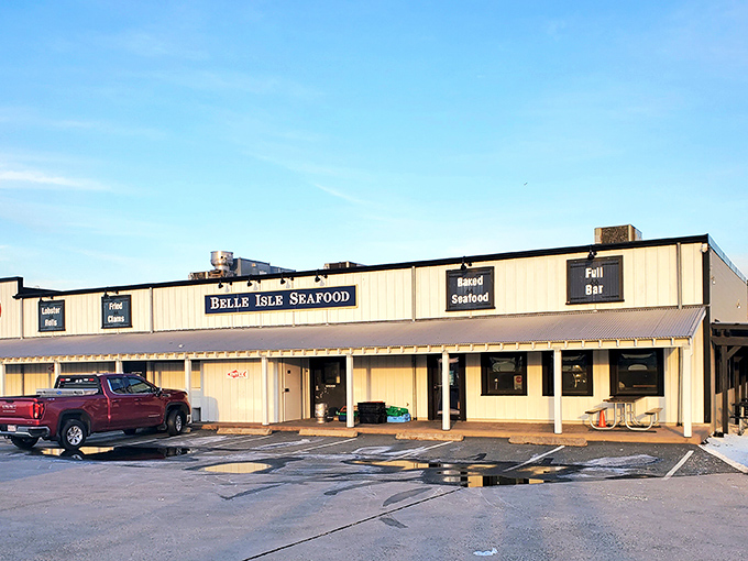 The unassuming exterior of seafood paradise – where luxury cars and work trucks share parking spaces in democratic pursuit of lobster perfection. 