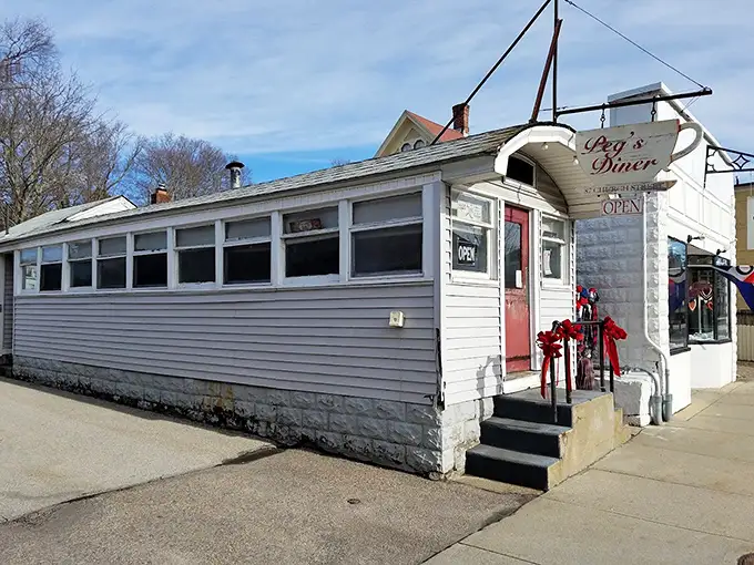 The unassuming white exterior with that pop of red door is like finding a treasure map in your attic—modest packaging, extraordinary reward inside.