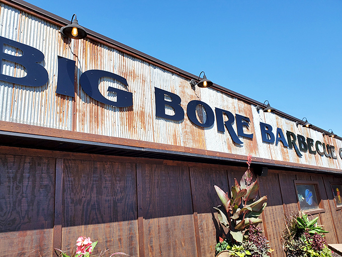 The weathered corrugated metal exterior of Big Bore Barbecue stands as a rustic beacon for meat lovers—industrial chic meets smokehouse authenticity.