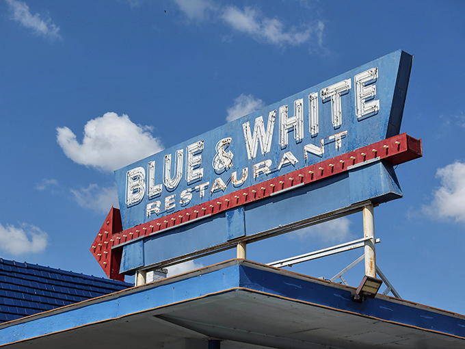 The iconic Blue & White sign stands like a beacon for hungry travelers, promising comfort food under that nostalgic gas station canopy. 