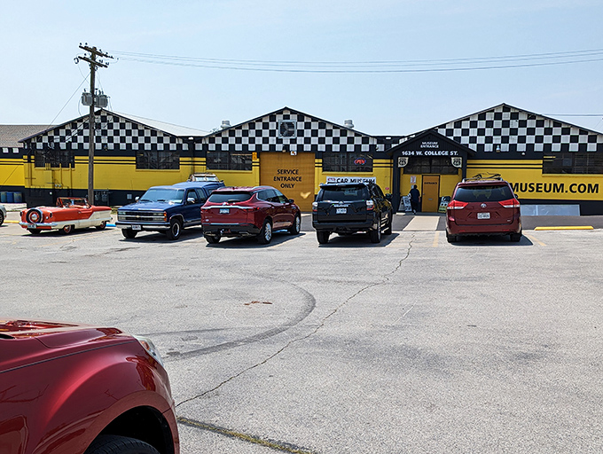 The classic checkered flag meets sunshine yellow on this roadside gem. A fitting beacon for automotive aficionados traveling along the Mother Road.
